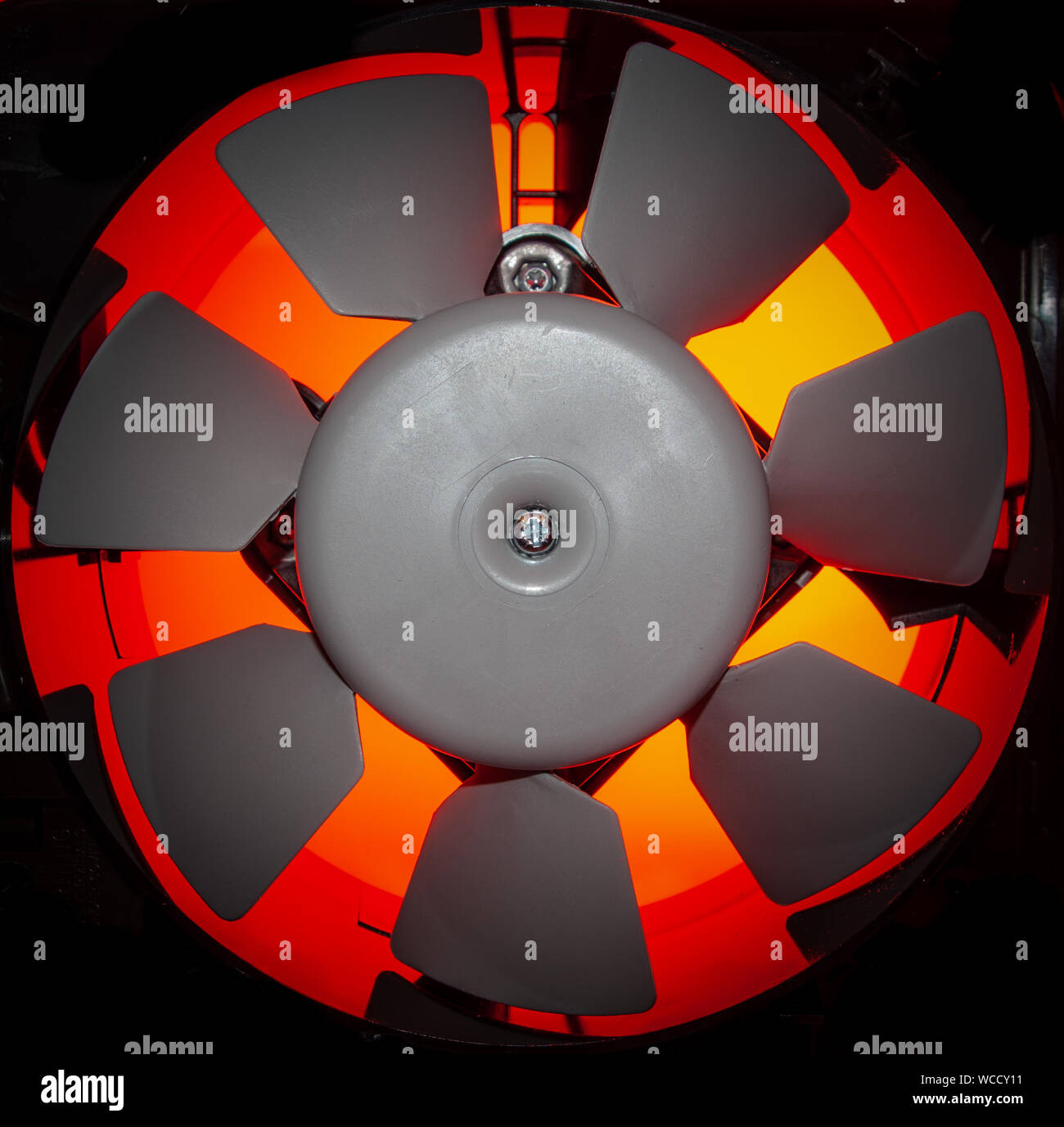 Plastic domestic extraction fan backlit with orange light through the ...