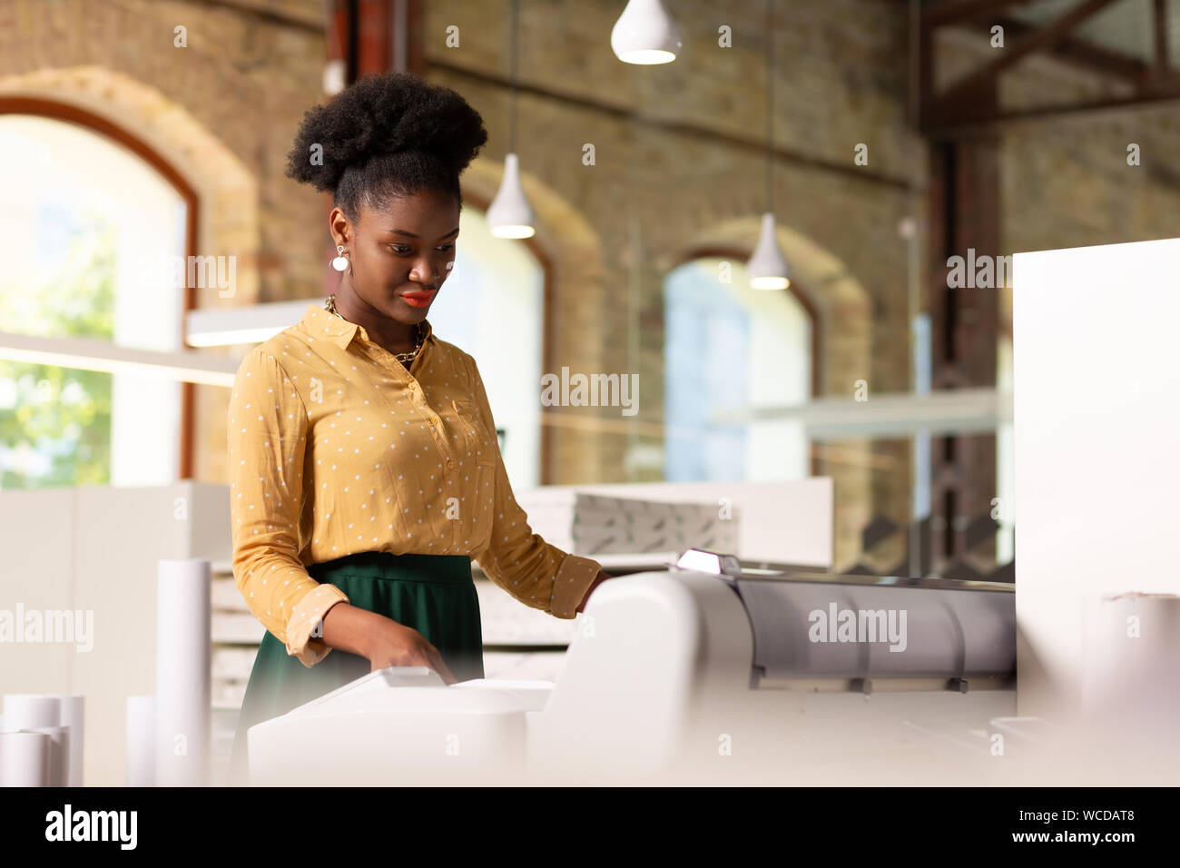 Worker of publishing agency using printer while working Stock Photo - Alamy