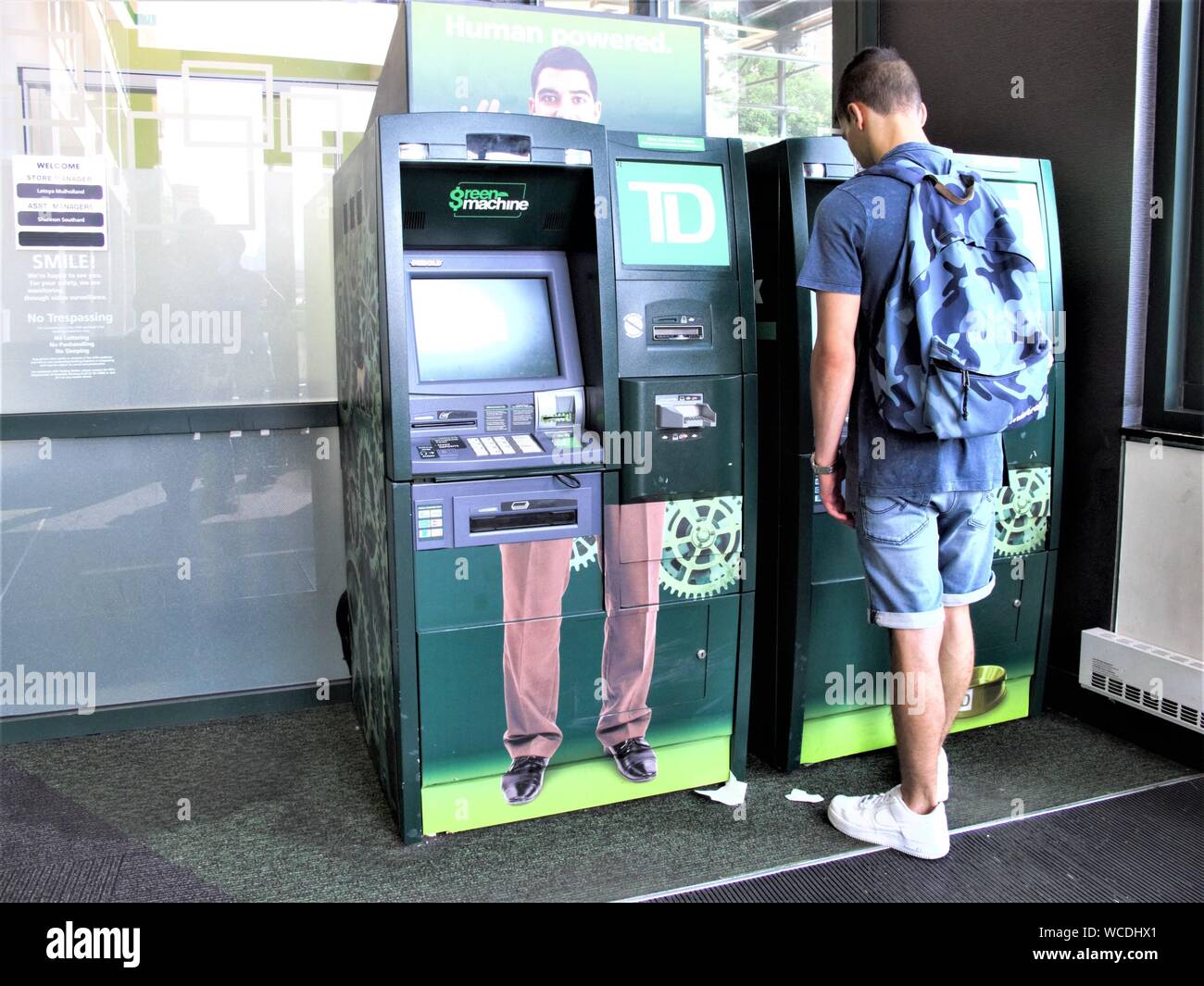A YOUNG MAN IN FRONT OF AN AUTOMATIC MACHINE OF THE TD BANK Stock Photo ...