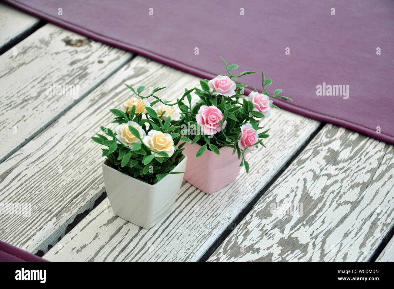 Artificial flowers in pots on the table. Table setting Stock Photo - Alamy
