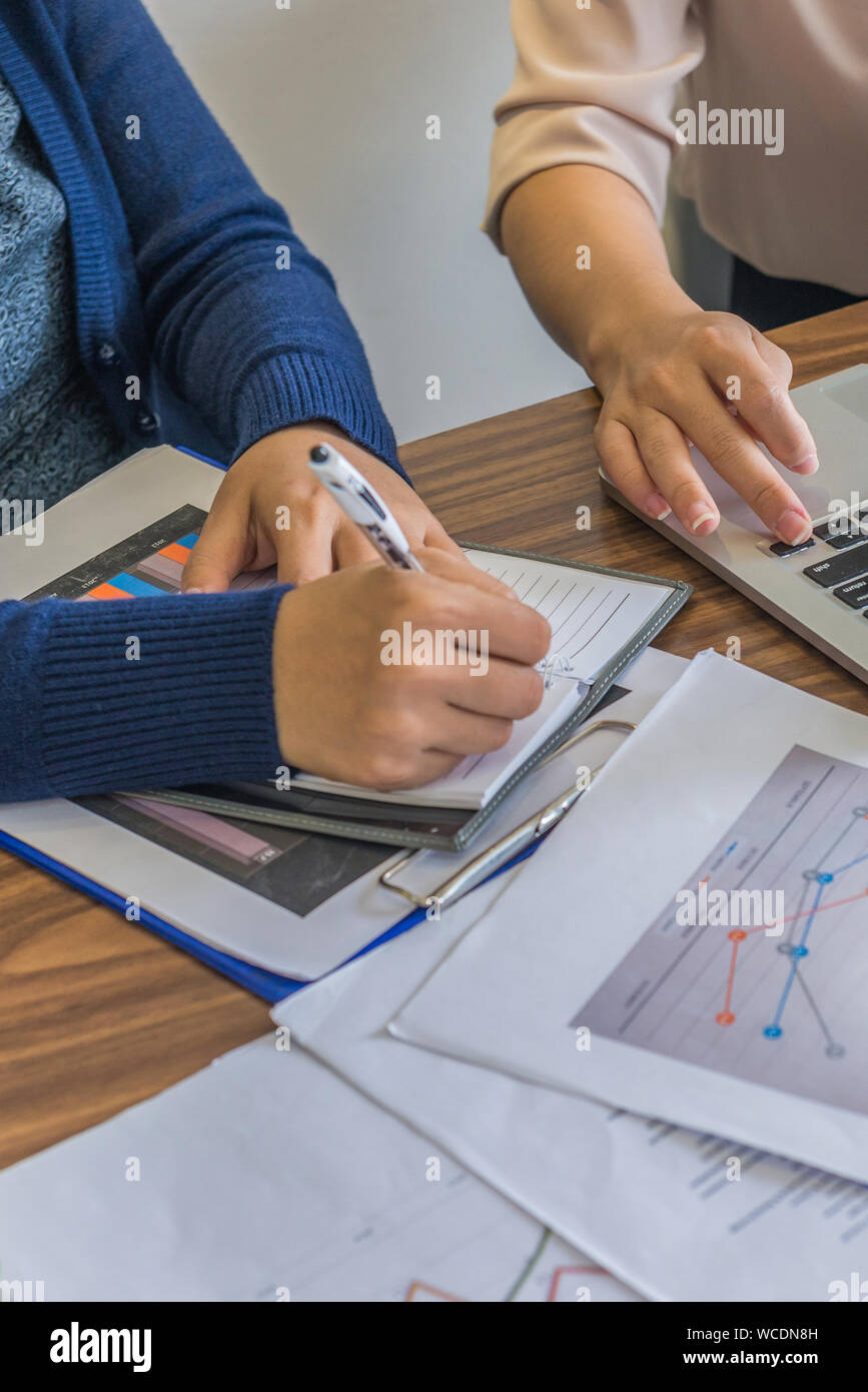 Vertical photo of businesswoman taking note while having meeting Stock ...