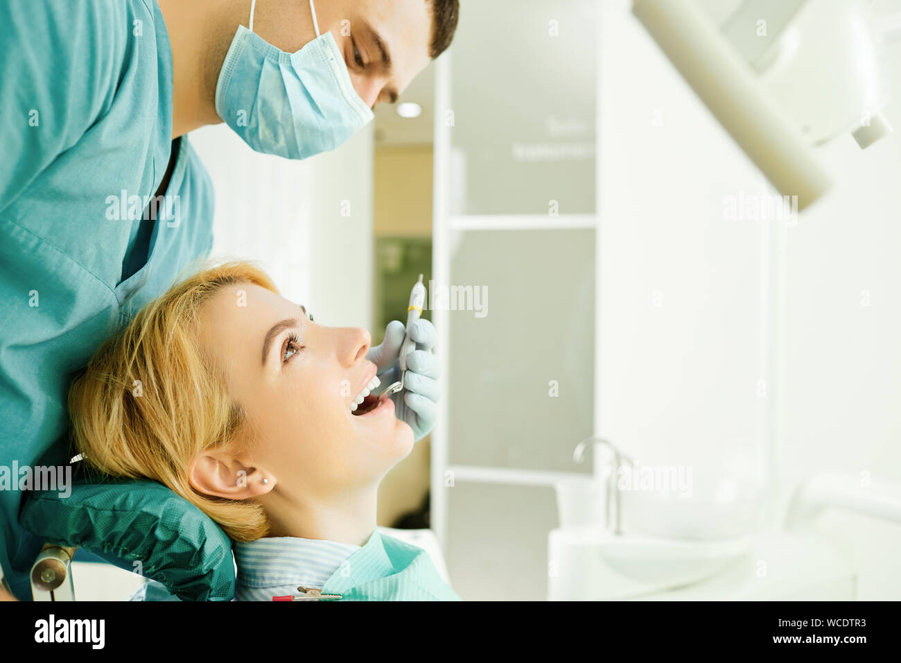 Dentist looking the teeth of the patient girl Stock Photo - Alamy