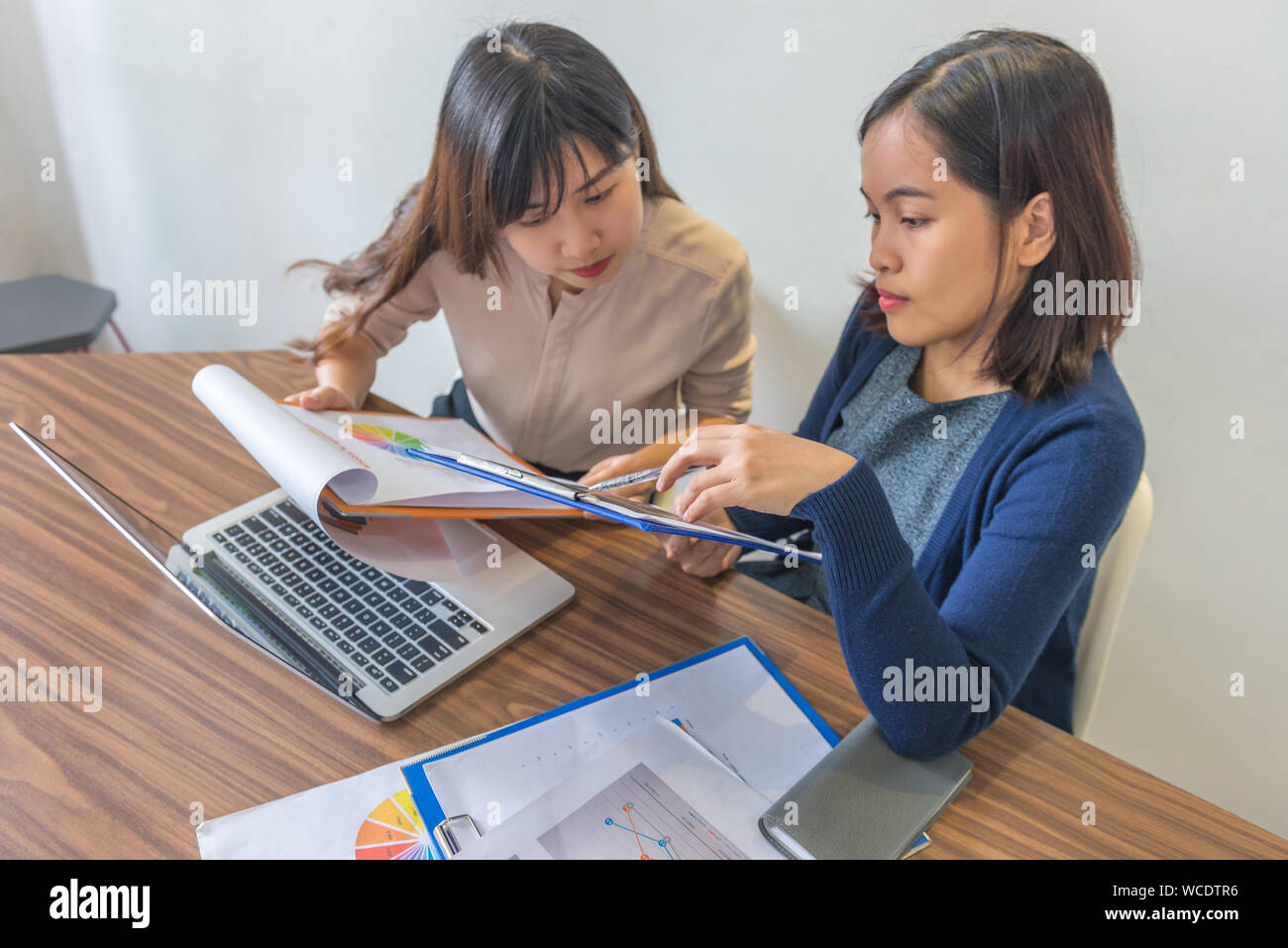 Two Asian female accountants working together on financial report ...