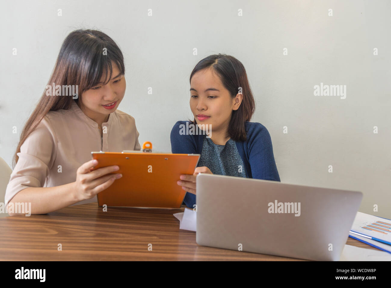 Two Asian office employees having business discussion at work Stock ...