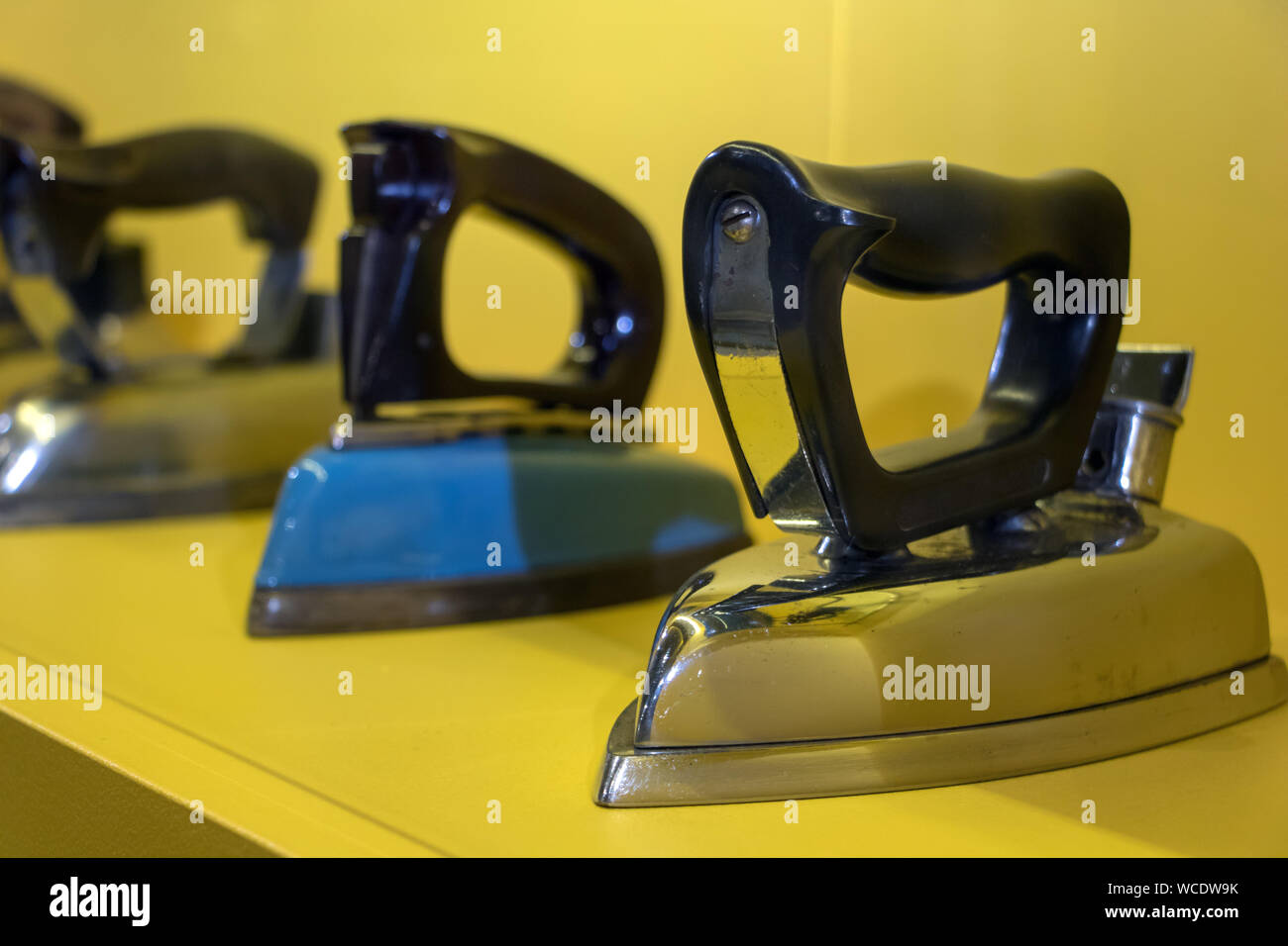 Collection of old irons on yellow background. Group of retro vintage ...