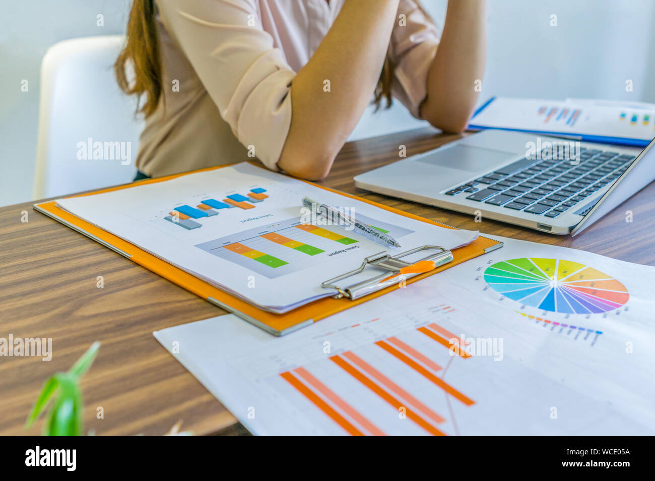 Woman sitting with diagram documents and laptop at workplace Stock ...