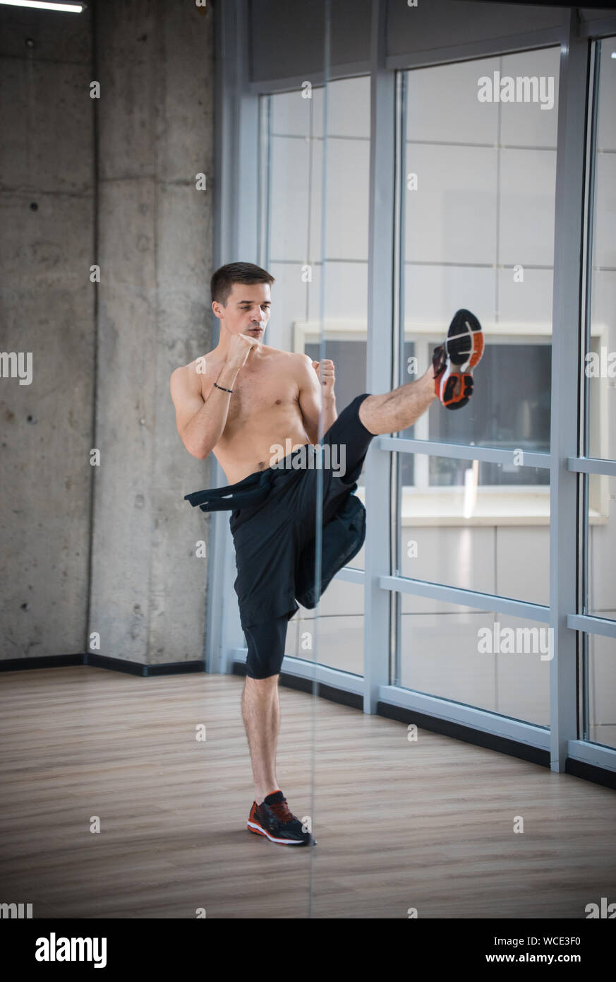 An athletic man standing in fighting pose in the studio - showing the ...