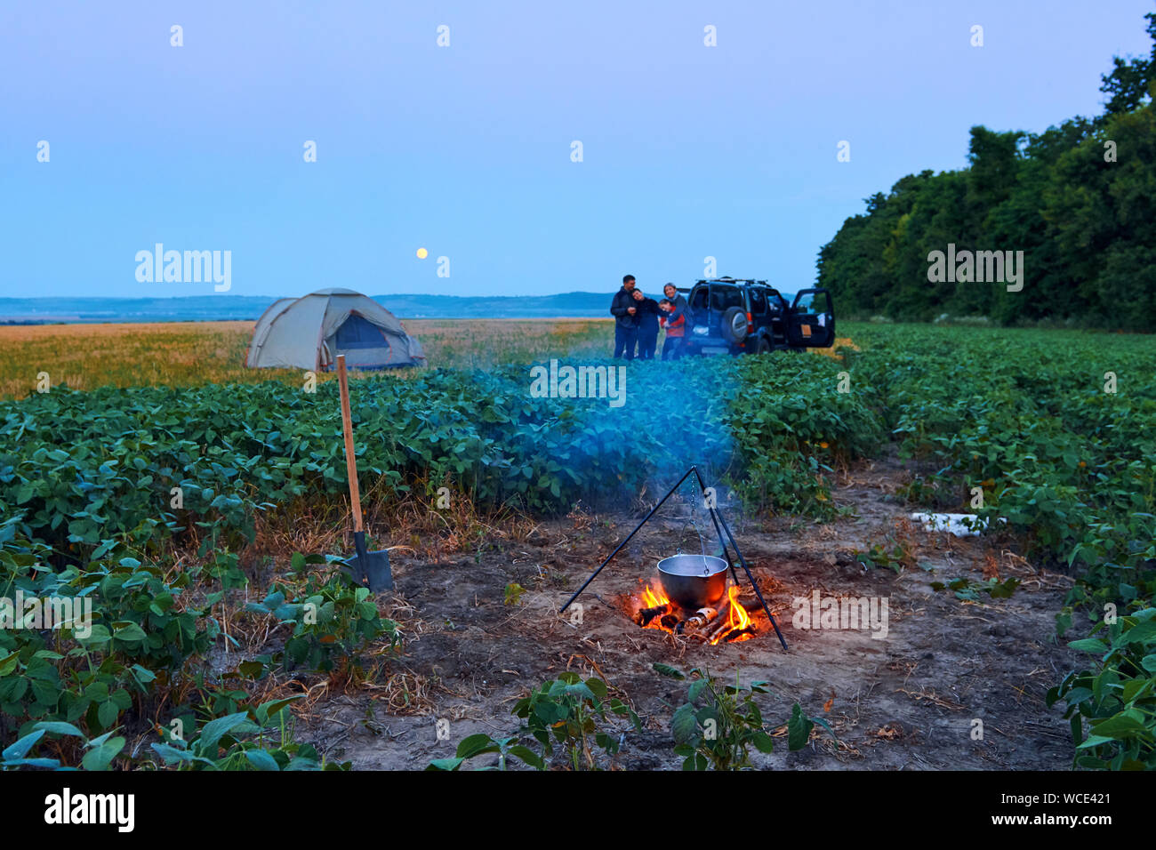 Family traveling and camping, twilight, cooking on the fire. Beautiful ...