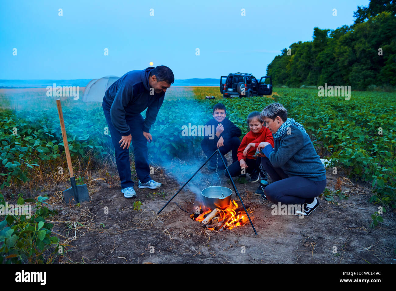 Family traveling and camping, twilight, cooking on the fire. Beautiful ...