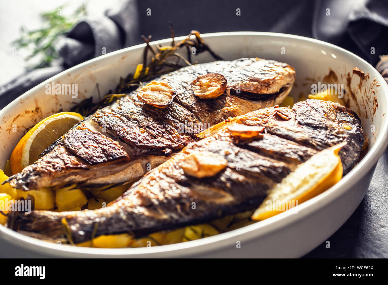Roasted mediterranean fish bream with potatoes rosemary and lemon Stock ...