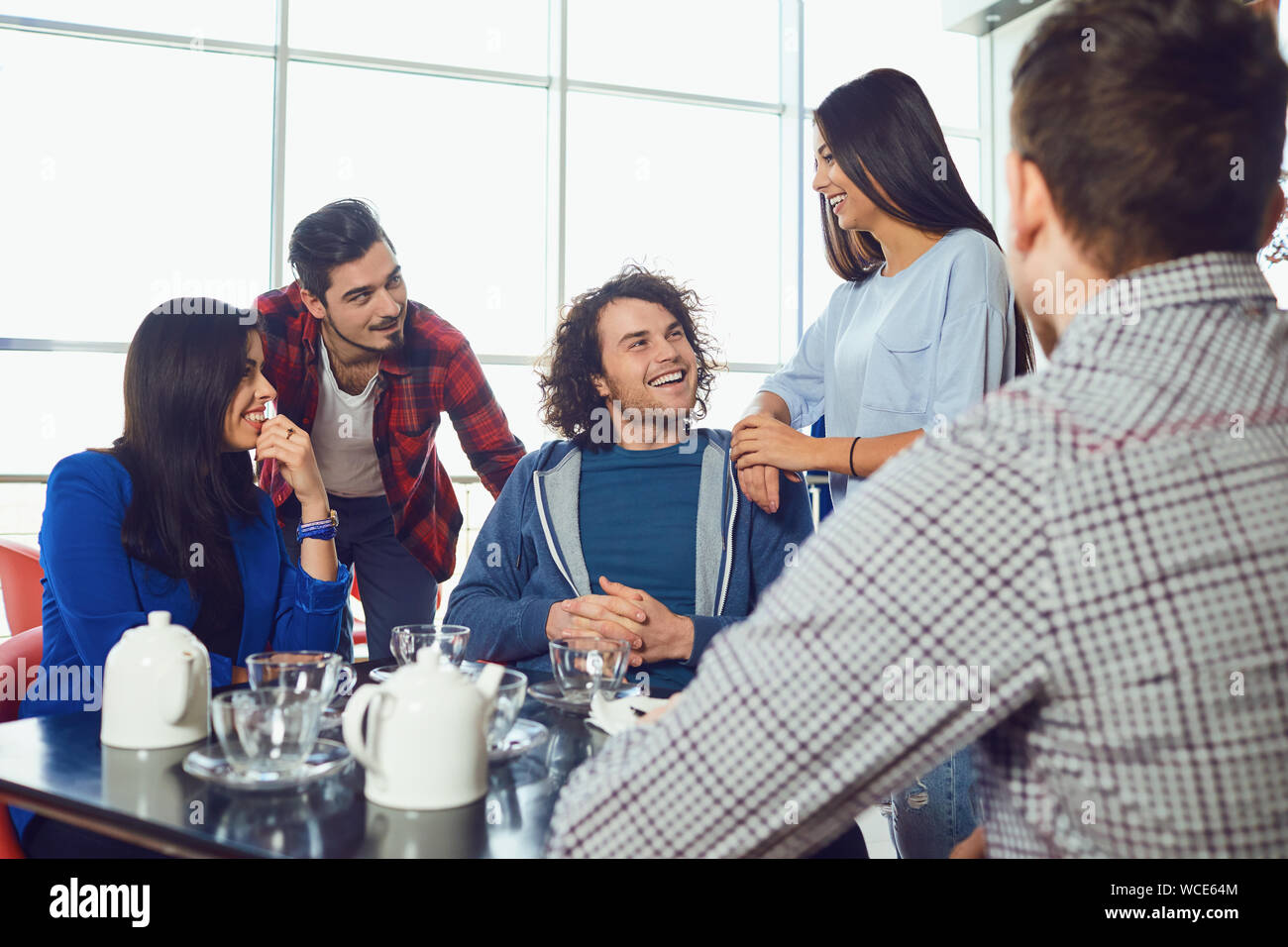 Funny friends talk and laugh in a cafe Stock Photo - Alamy