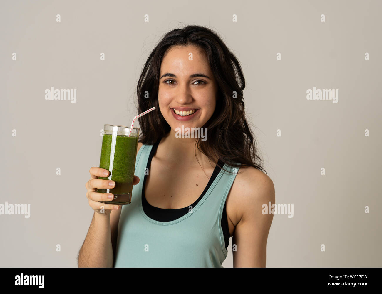 Happy fitness woman drinking green vegetable detox smoothie after ...