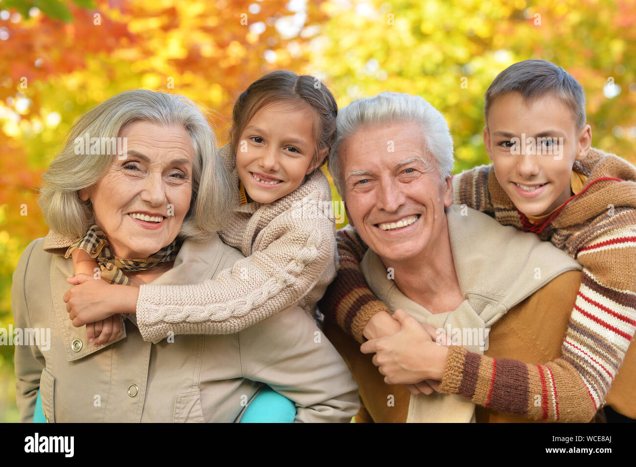 Portrait of grandparents with grandchildren posing outdoors in autumn ...