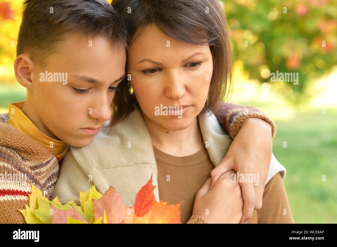 Sad mother and son in autumn park Stock Photo - Alamy