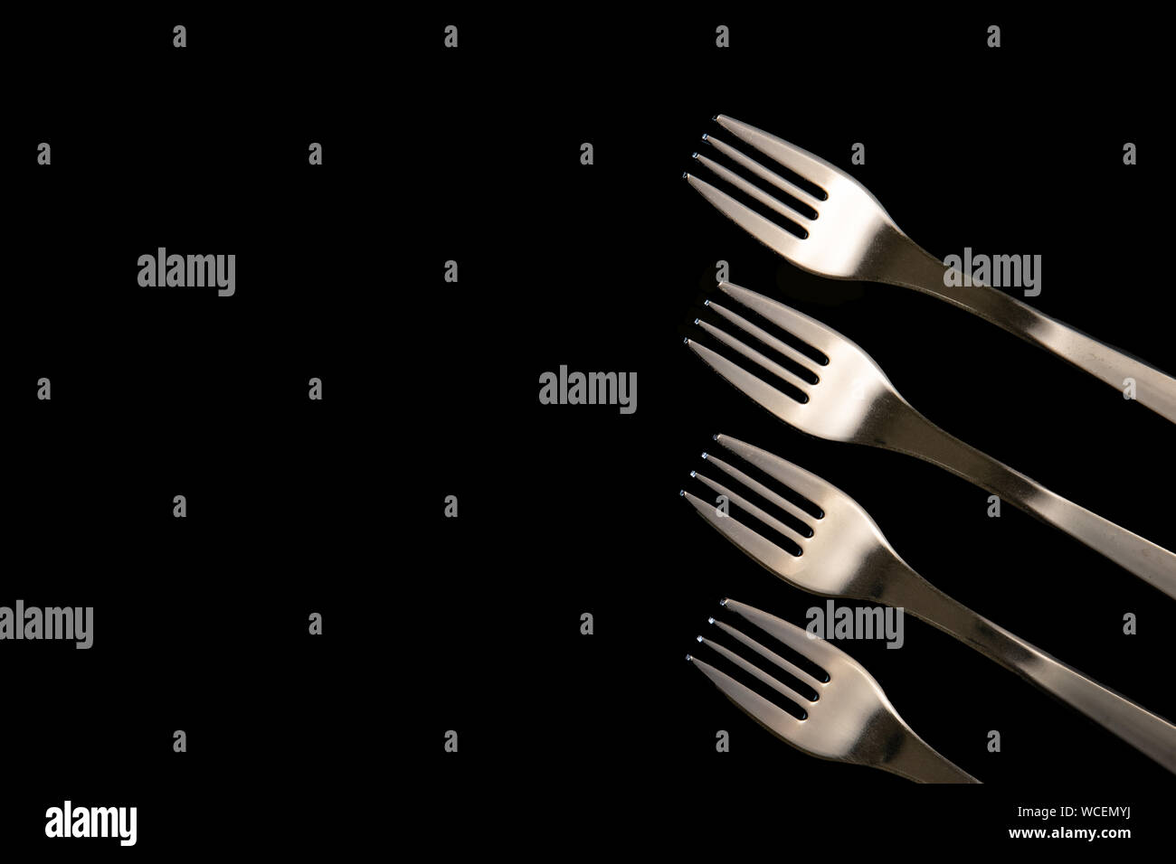 metal forks on a black background. top view on stainless forks with ...
