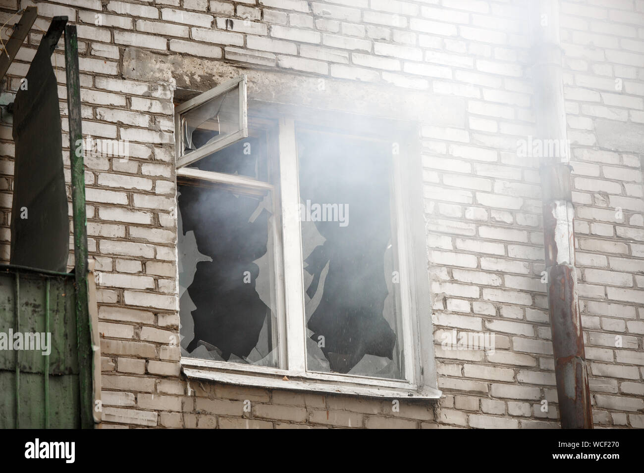 Picture of grey brick house with smoke coming out of window during day ...