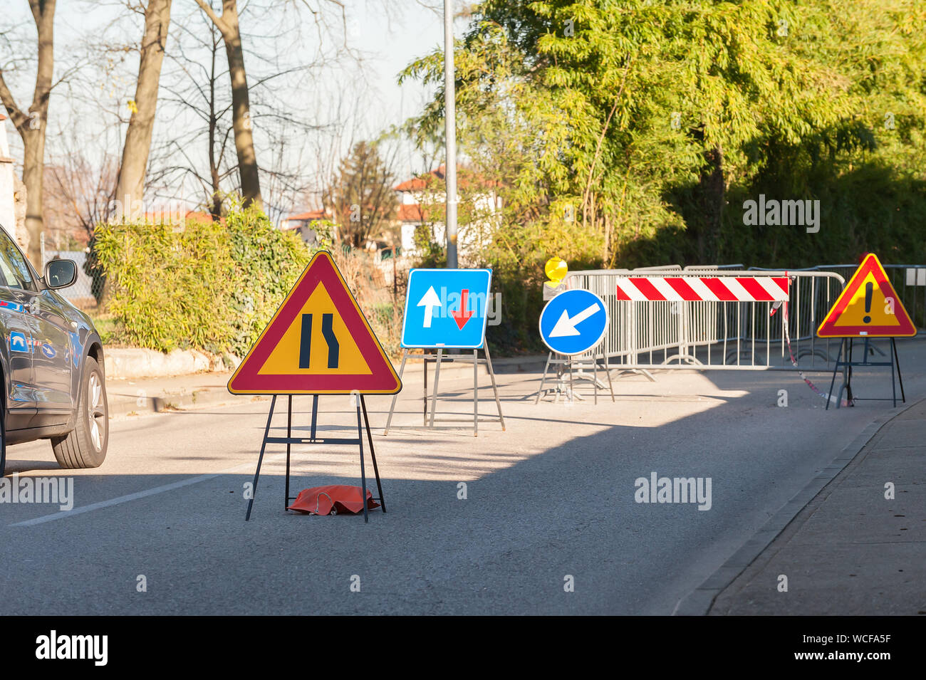 Road Signs On Street Against Trees Stock Photo - Alamy