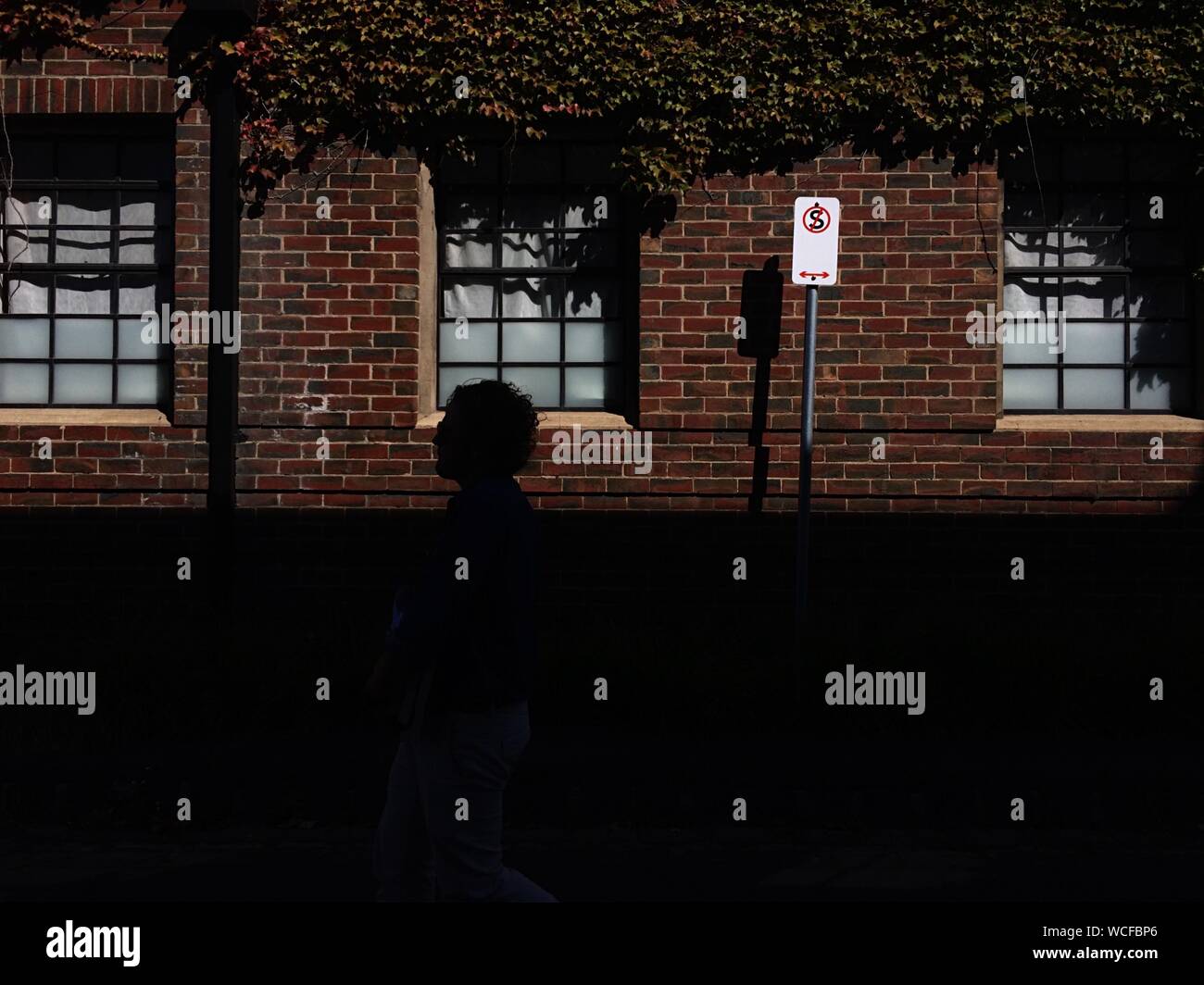 Side View Of Man Against Brick Wall Stock Photo - Alamy