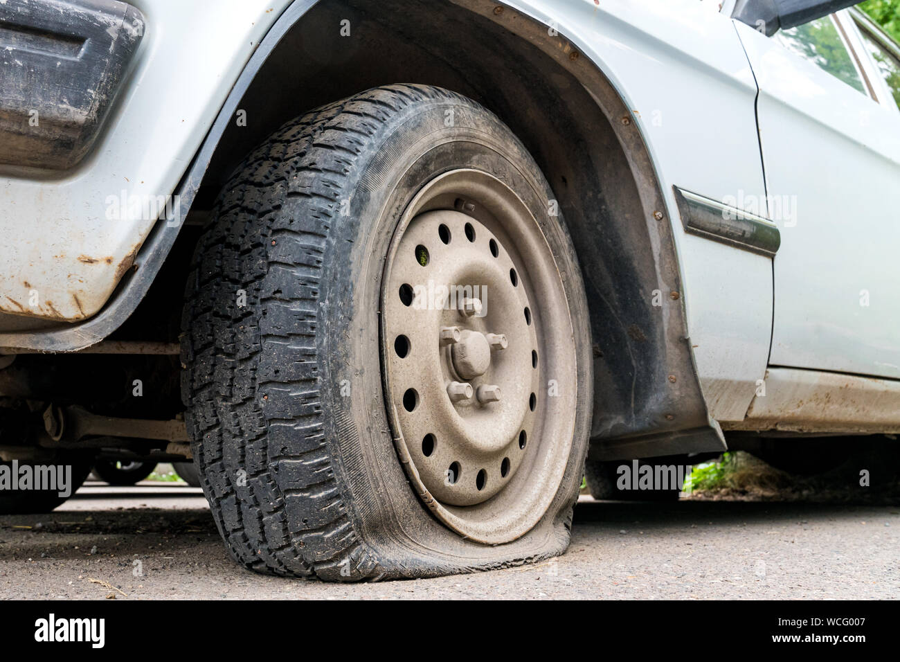 car wheel flat tire on the road Stock Photo - Alamy