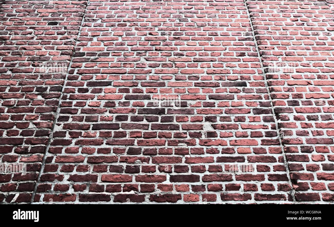 Detailed closeup view on aged and weathered red bricks walls in a ...