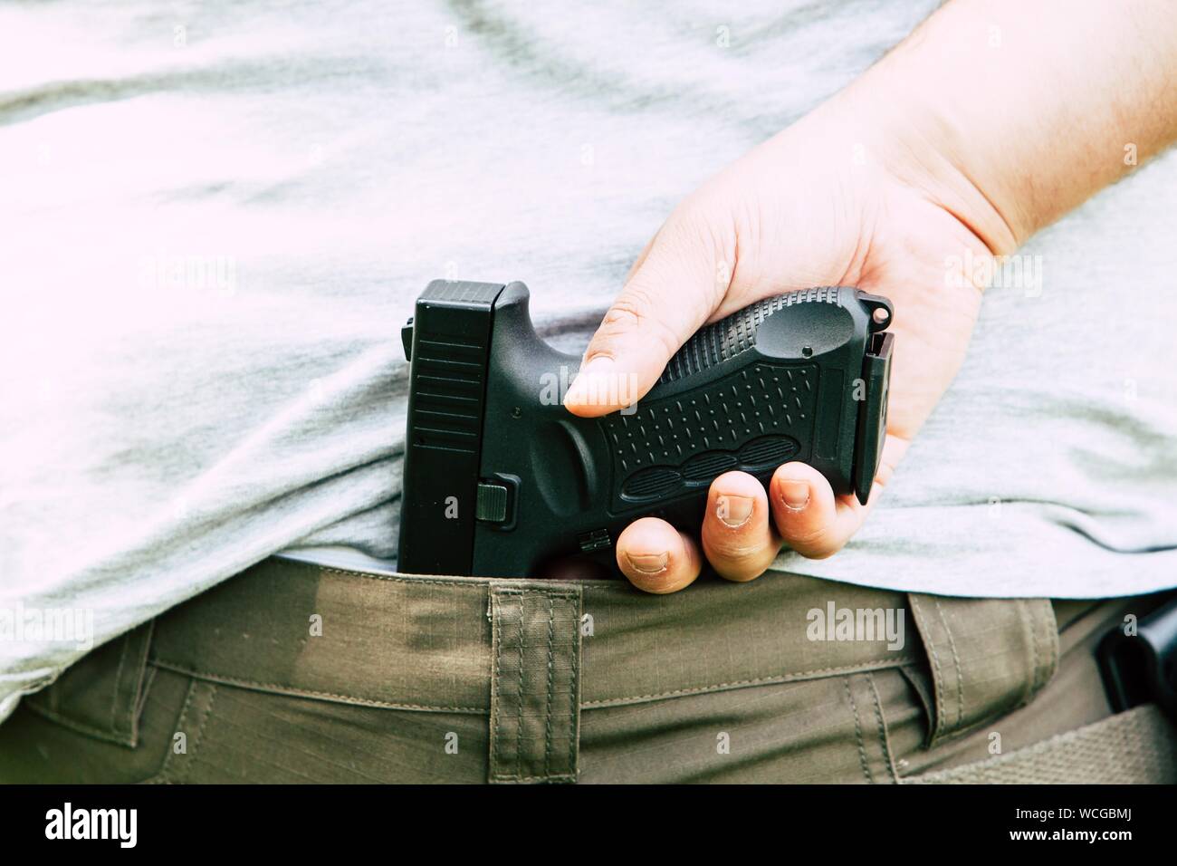 Rear view man holding gun hi-res stock photography and images - Alamy