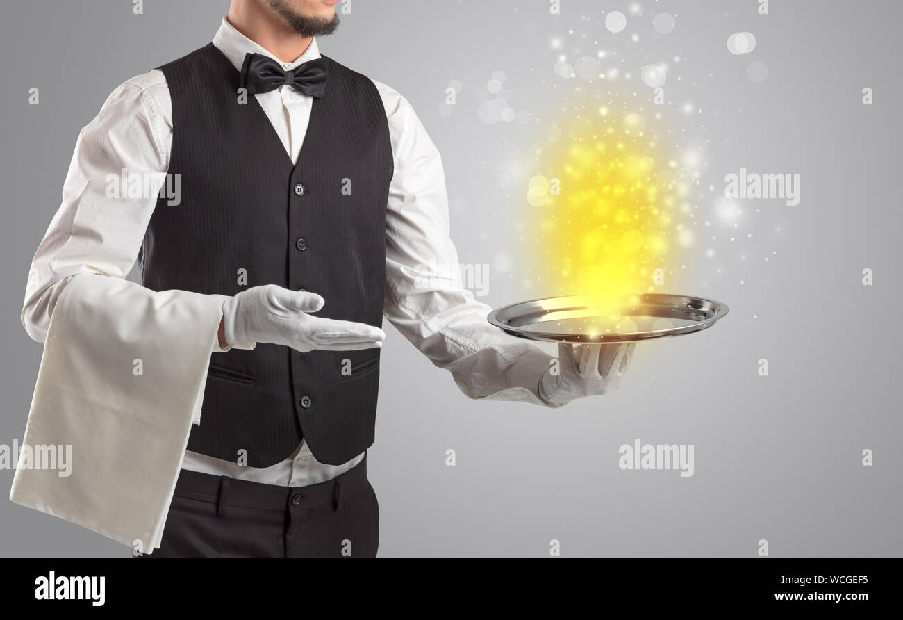 Elegant young waiter serving mysterious light on tray Stock Photo - Alamy