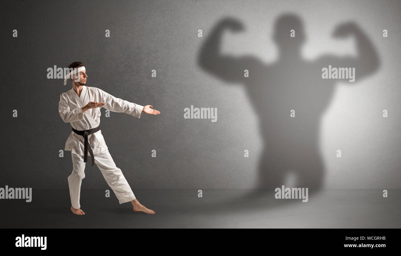Young karate man fighting with a big black scary shadow Stock Photo - Alamy