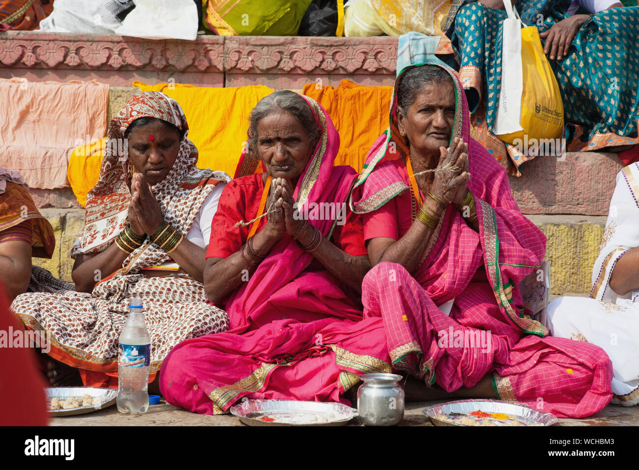 India, Uttar Pradesh, Varanasi, Pilgrims pray on the ghats beside the ...