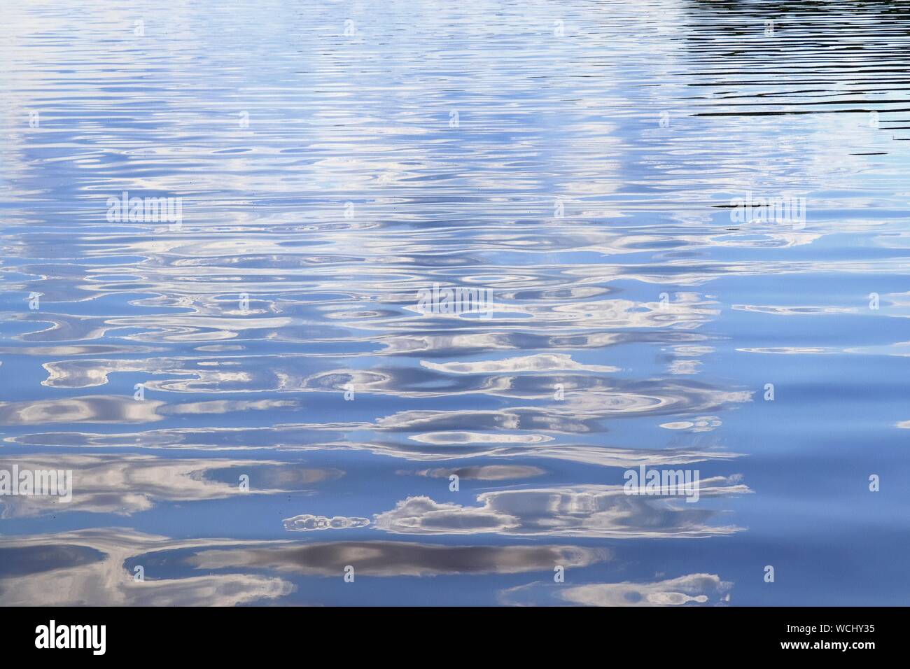 Detailed close up view on water surface with reflection sunlight at the ...