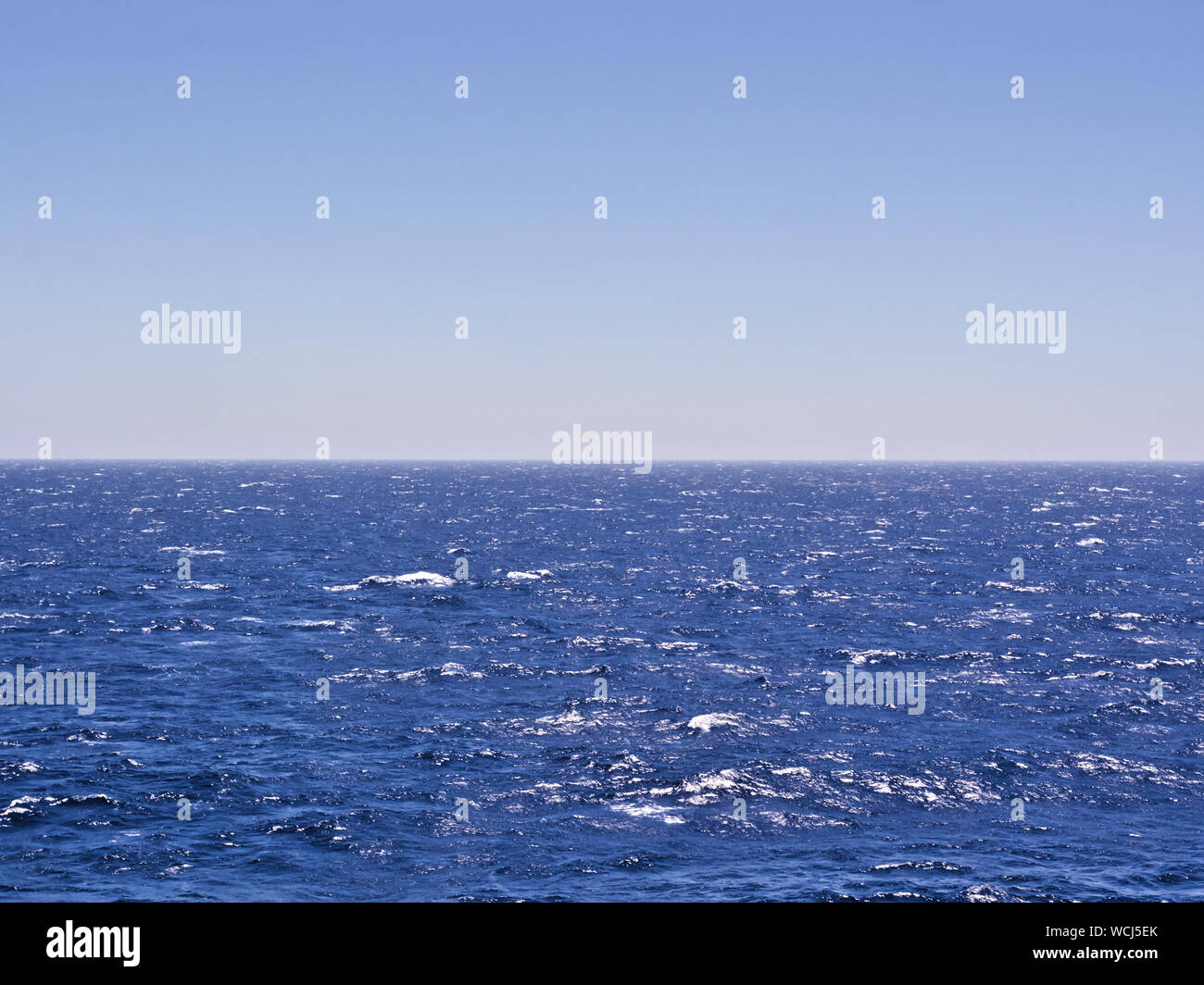 Wavy deep blue sea and sky. Horizon line in the middle of the frame Stock Photo - Alamy