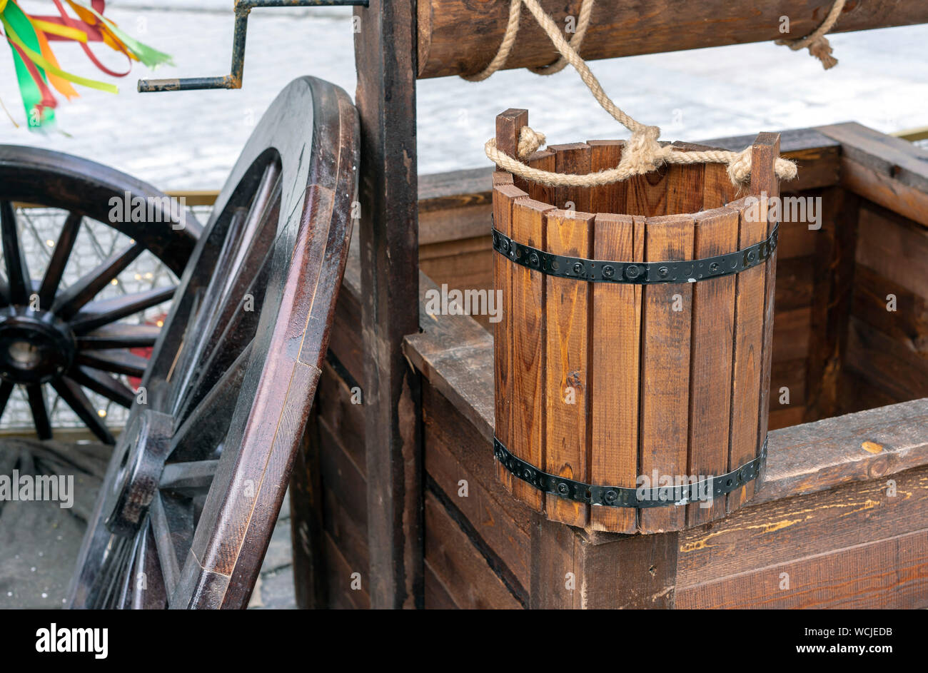 Wooden water well with a bucket tied on a rope Stock Photo - Alamy