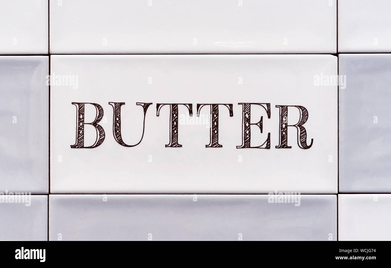 Ceramic tile with the inscription "Butter". Background and texture of ...