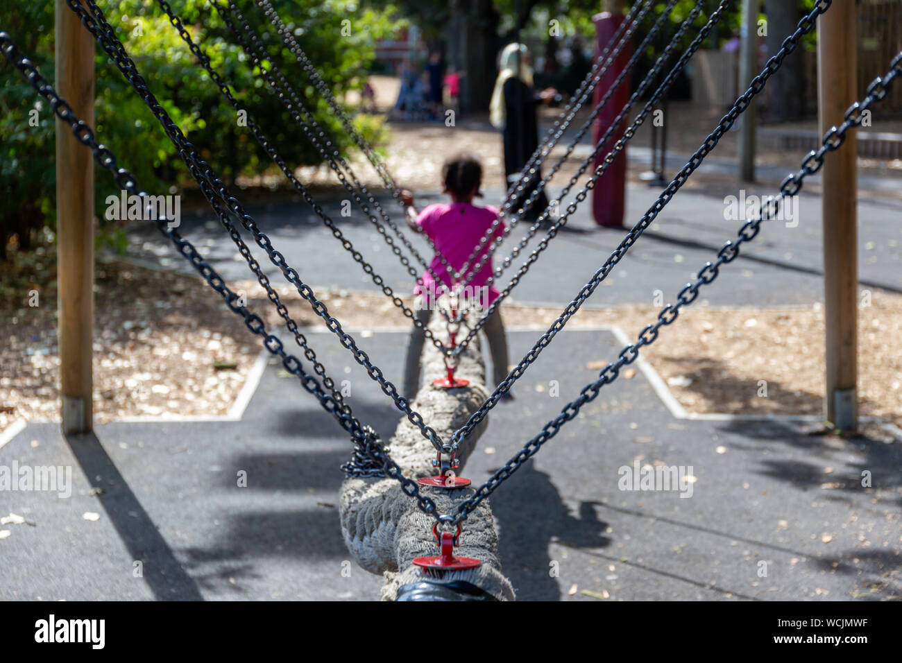 Child riding a rope snake swing in the playground at Battersea Park ...
