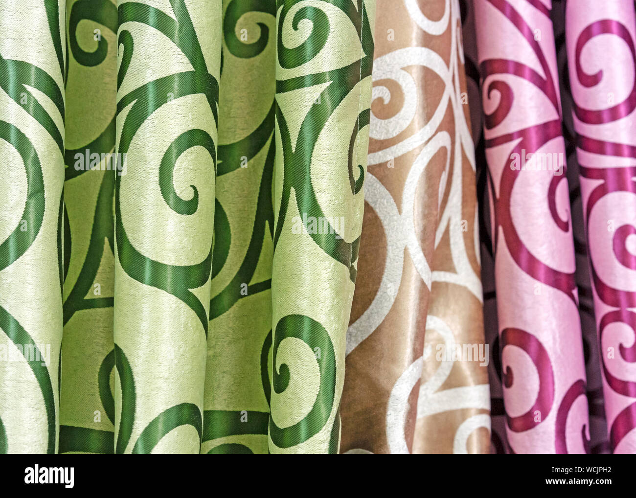 Multicolored curtain designs in a retail store window. Samples of the ...