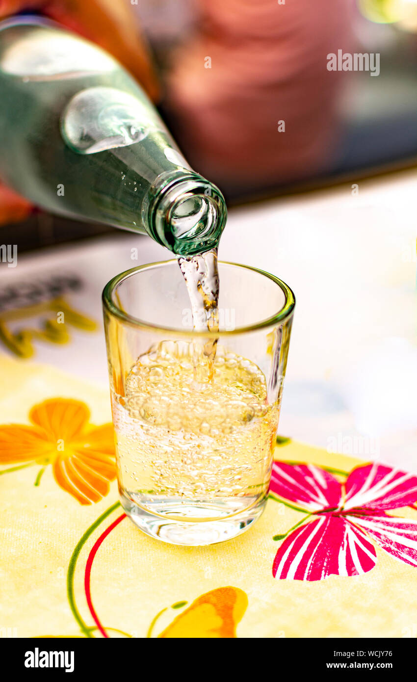 Pouring of cold mineral water from bottle in glass Stock Photo - Alamy