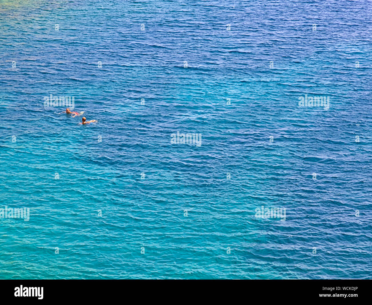 Chios island, Greece - August 4, 2019: Two men swiming in crystal clear ...