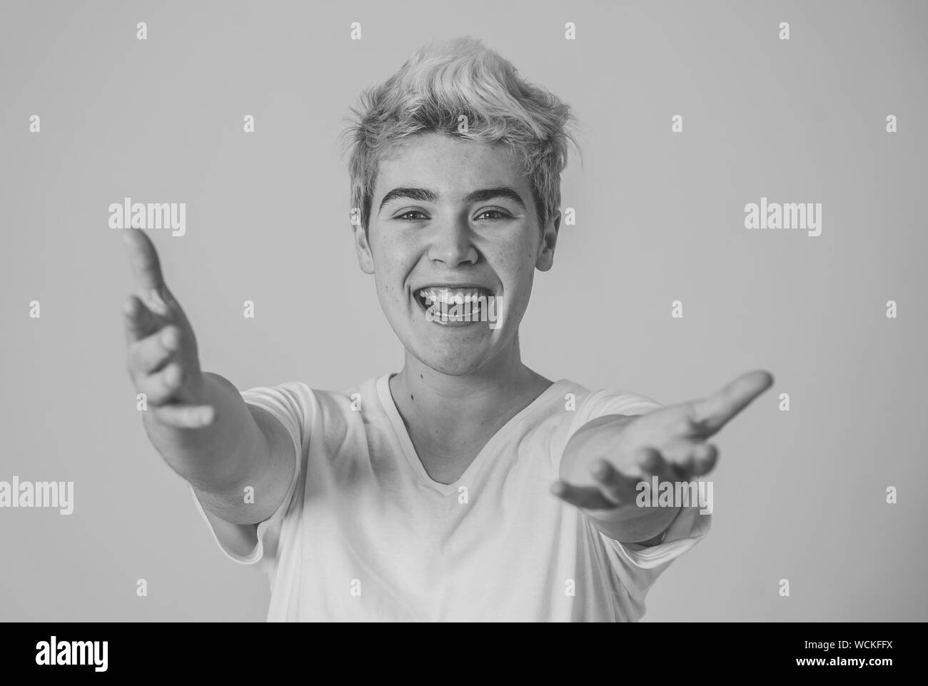 Portrait of good looking young teenager man welcoming with open arms ...