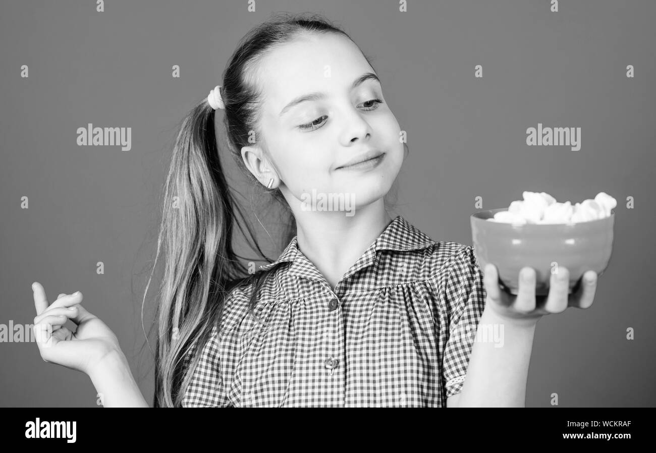 Girl smiling face hold bowl sweets marshmallows in hand blue background ...
