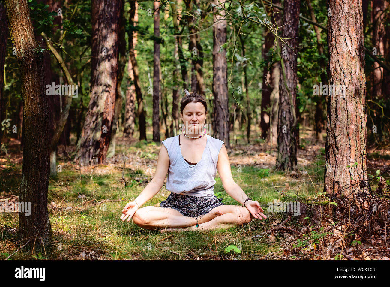 young woman meditating alone and silent in summer forest Stock Photo ...