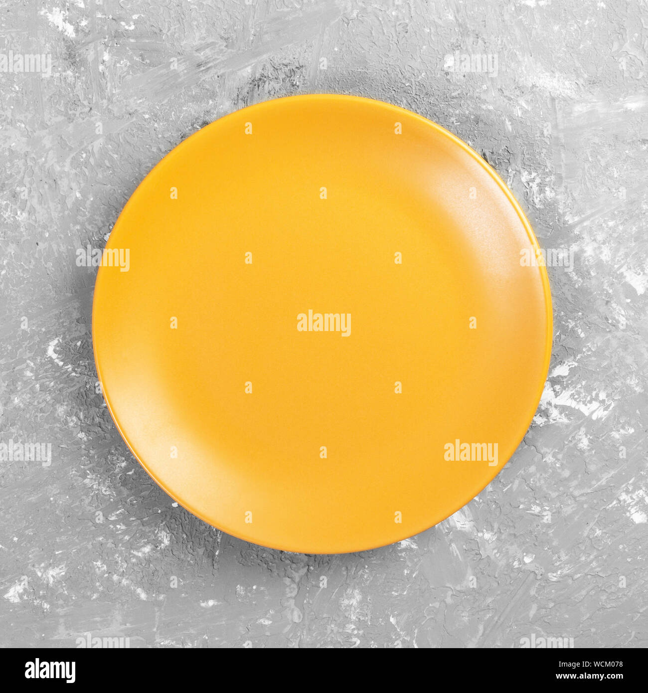 Yellow Round Plate on grey cement table background. Top view, template ...