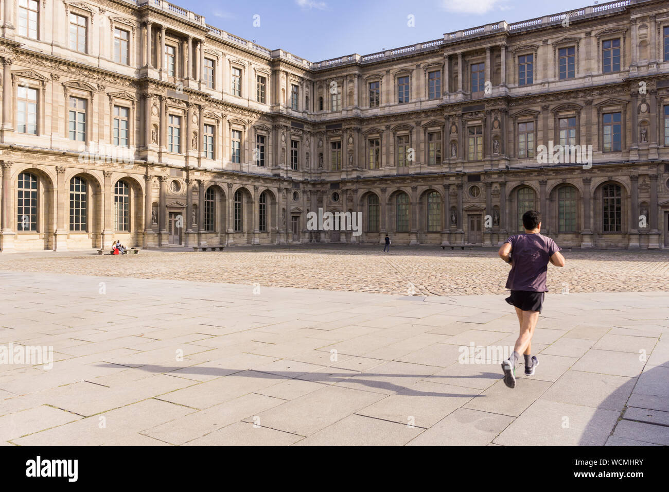 Paris runner - a man running through the Louvre courtyard in Paris ...