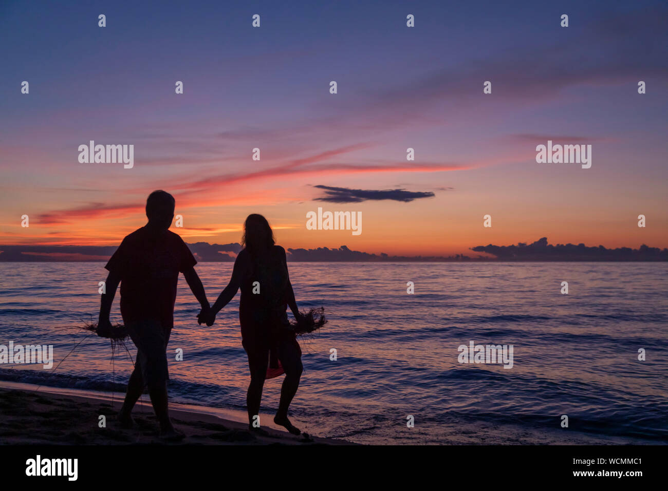 Union Pier, Michigan - A couple walks on the beach as the sun sets over ...