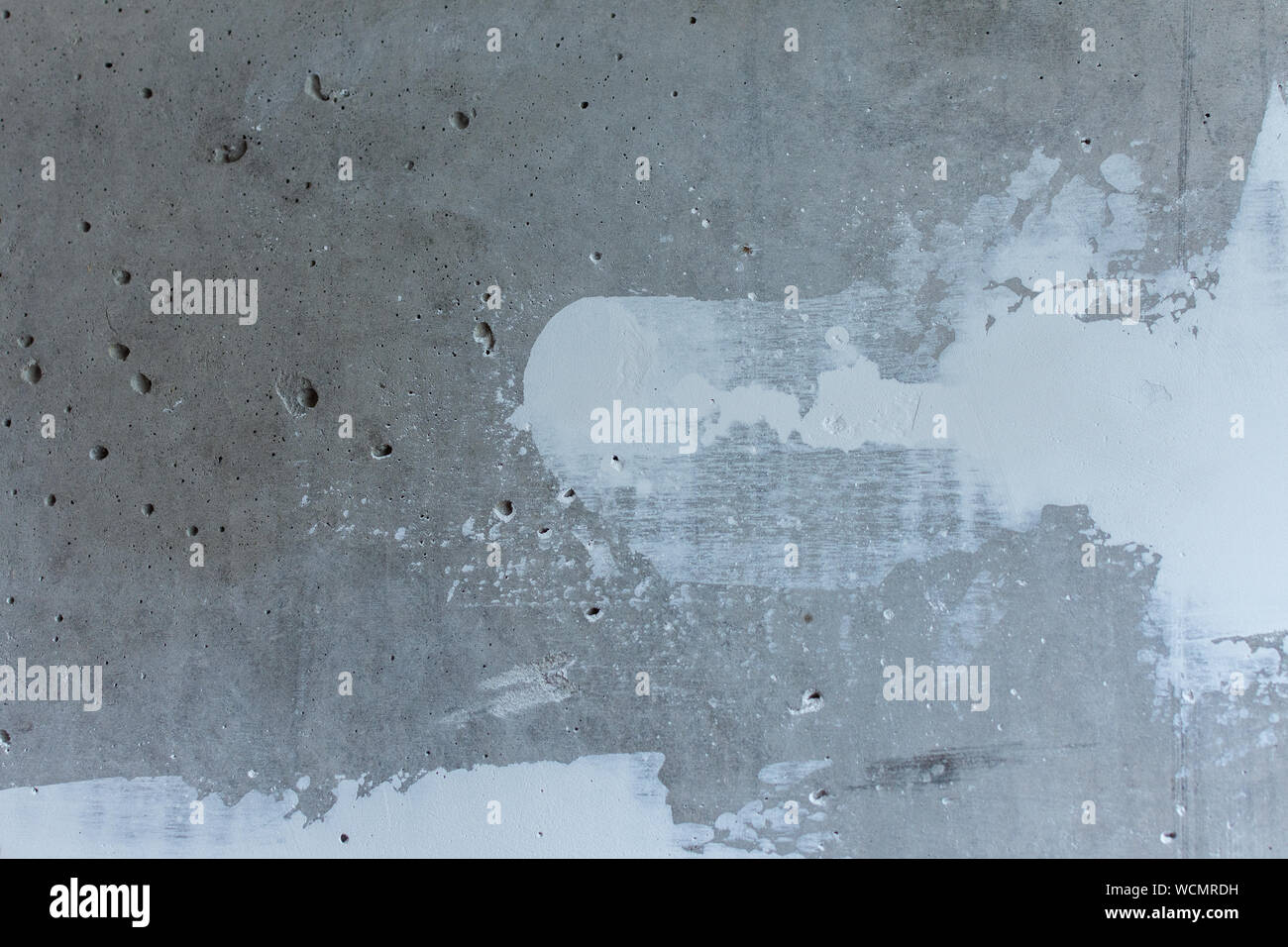 Puttying the wall with white putty, concrete wall with smeared ...