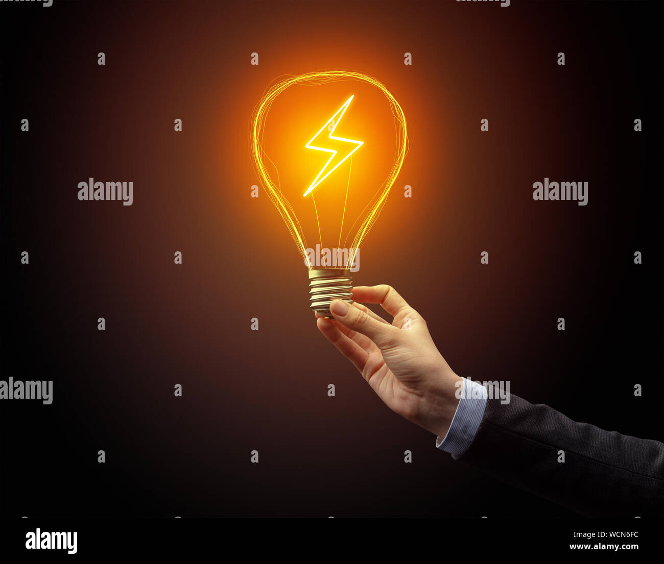 Hand holding light bulb on dark background. New Eco idea concept Stock ...