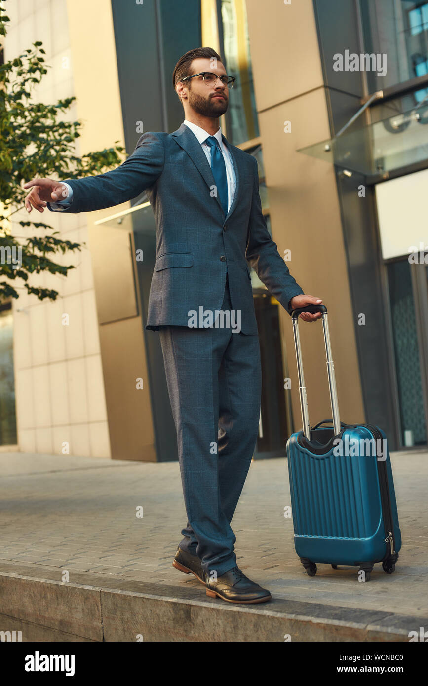 Catching taxi. Full length of young and handsome bearded man in suit ... Catching taxi. Full length of young and handsome bearded man in suit ...