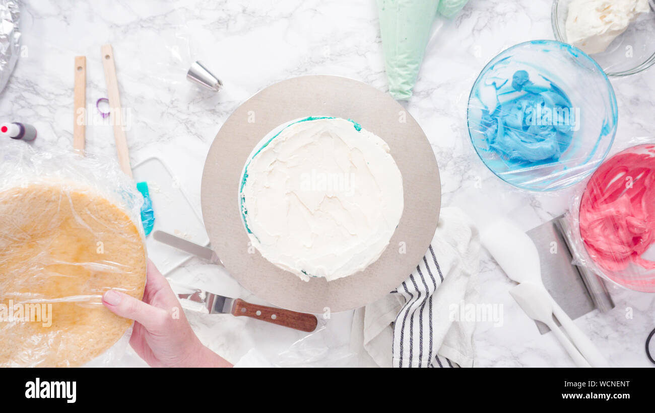 Stacking cake layers to create the round three-layer vanilla cake Stock ...