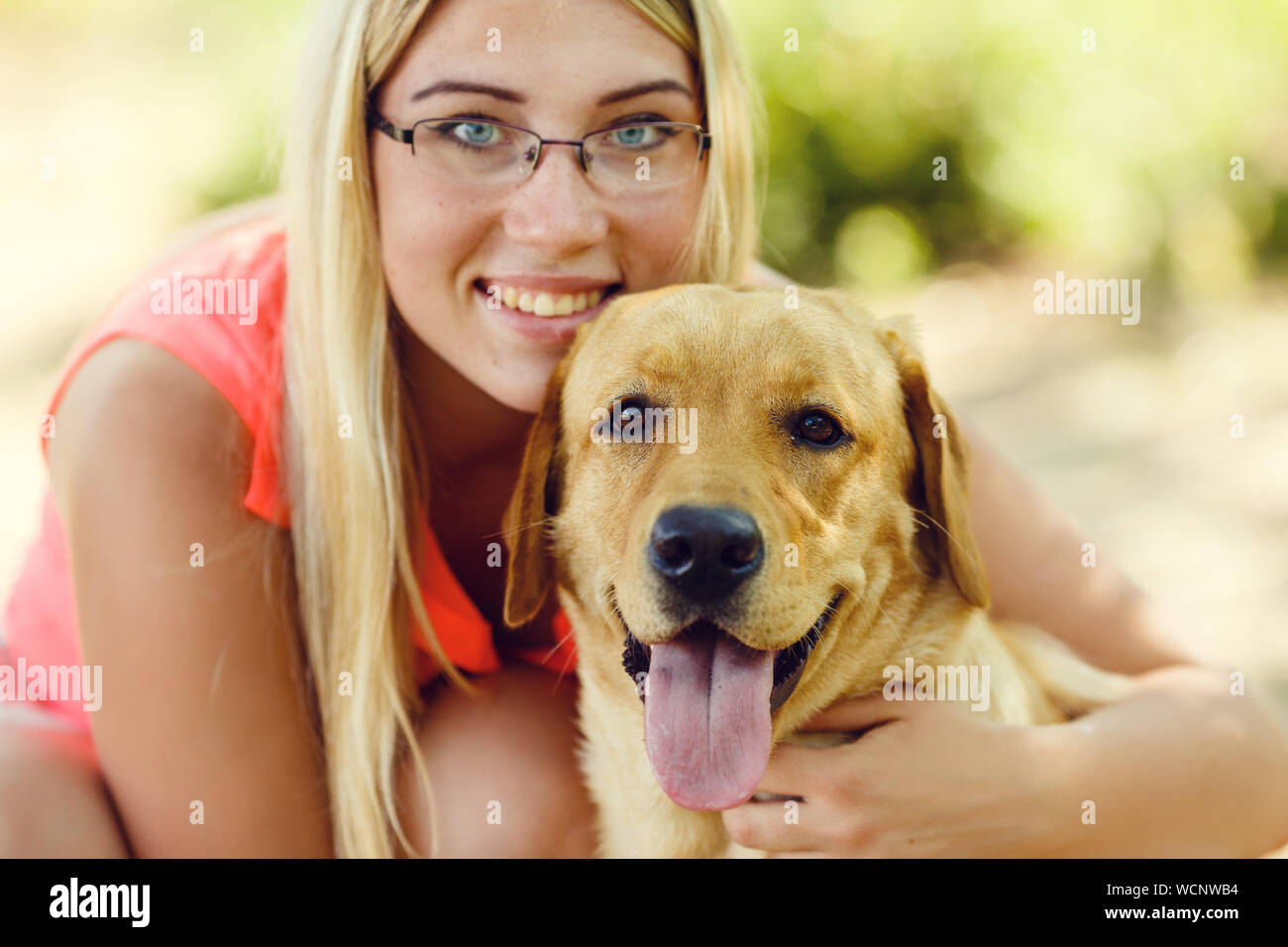 portrait of Beautiful young girl with her dog labrador retriever ...