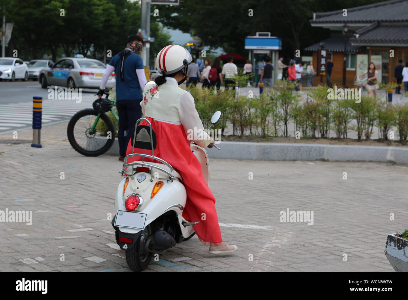 Rear View Of Woman Riding Motor Scooter On Street Stock Photo - Alamy