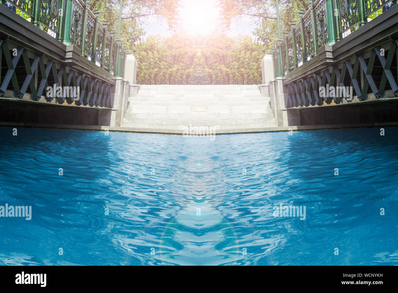 Stone quay with stairs on bank between two bridges across water channel ...