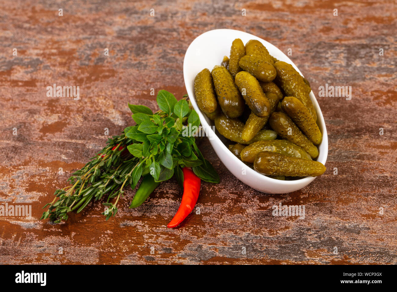 Pickled small cucumbers in the bowl served herbs Stock Photo - Alamy